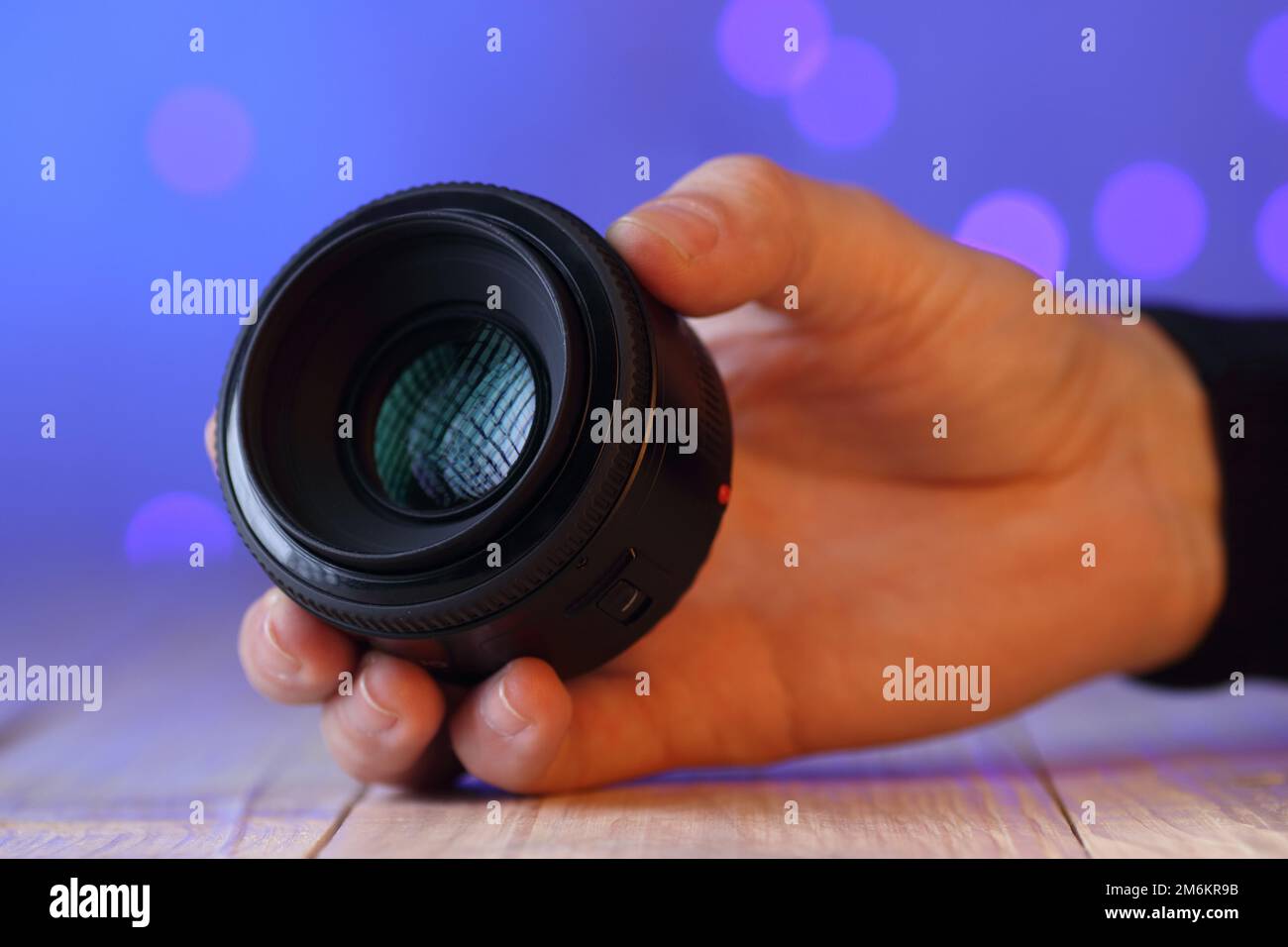 chinese 50 mm lens in hand on table and colored background Stock Photo ...