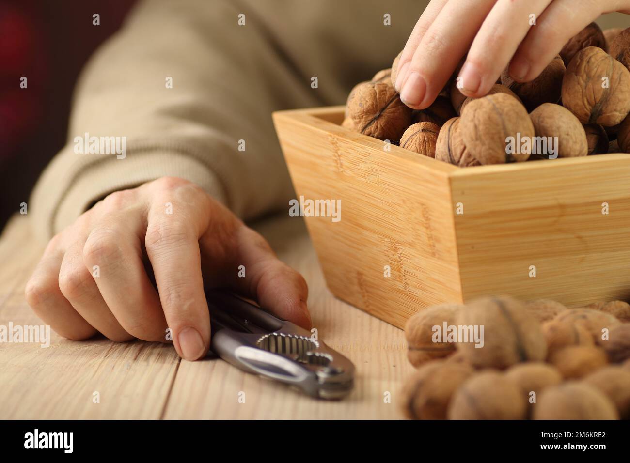 nutcracker held in hand next to a box of nuts Stock Photo - Alamy