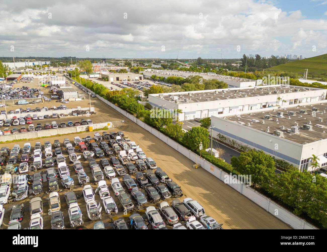 Aerial photo of a car junk yard next to warehouses Stock Photo - Alamy