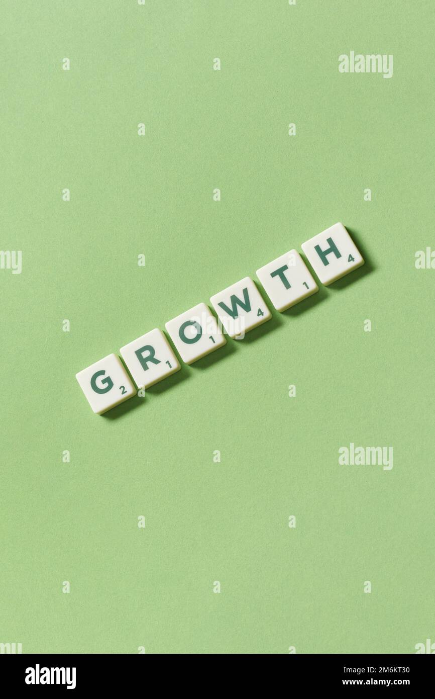 Growth formed of scrabble blocks on green background Stock Photo - Alamy