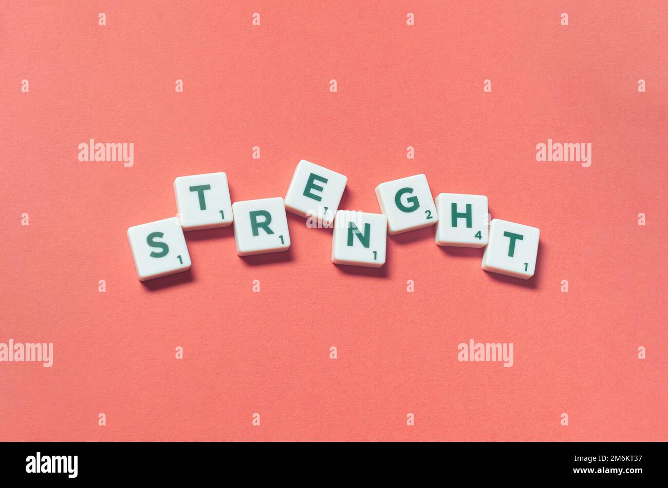 Strength formed of scrabble blocks on red background Stock Photo - Alamy