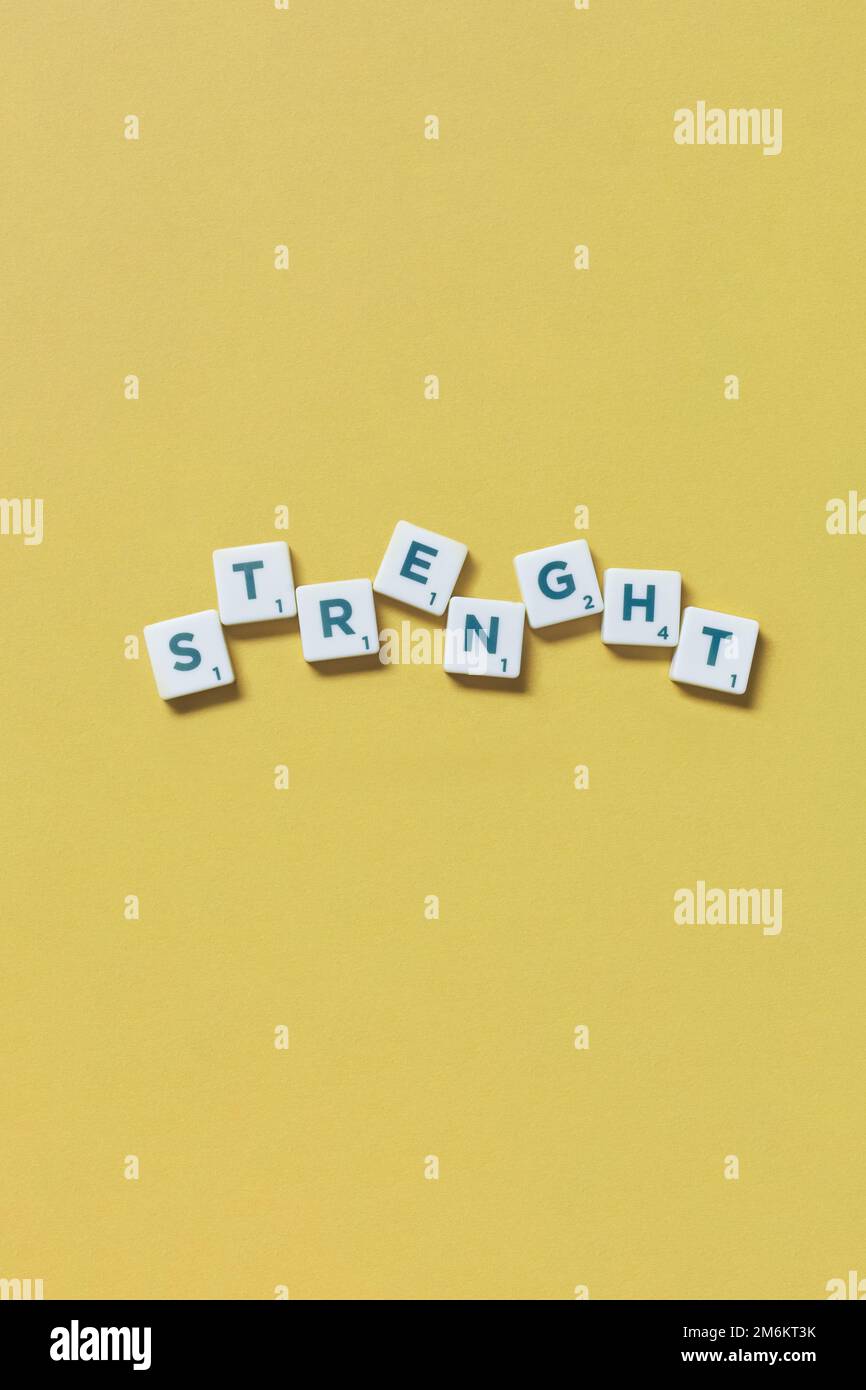 Strength formed of scrabble elements on yellow background Stock Photo ...