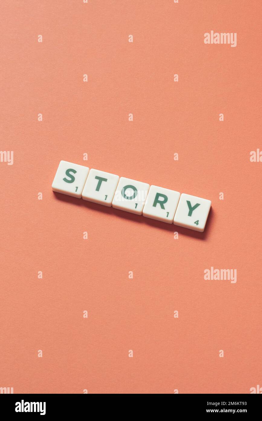 Story formed of scrabble tiles on orange background Stock Photo - Alamy