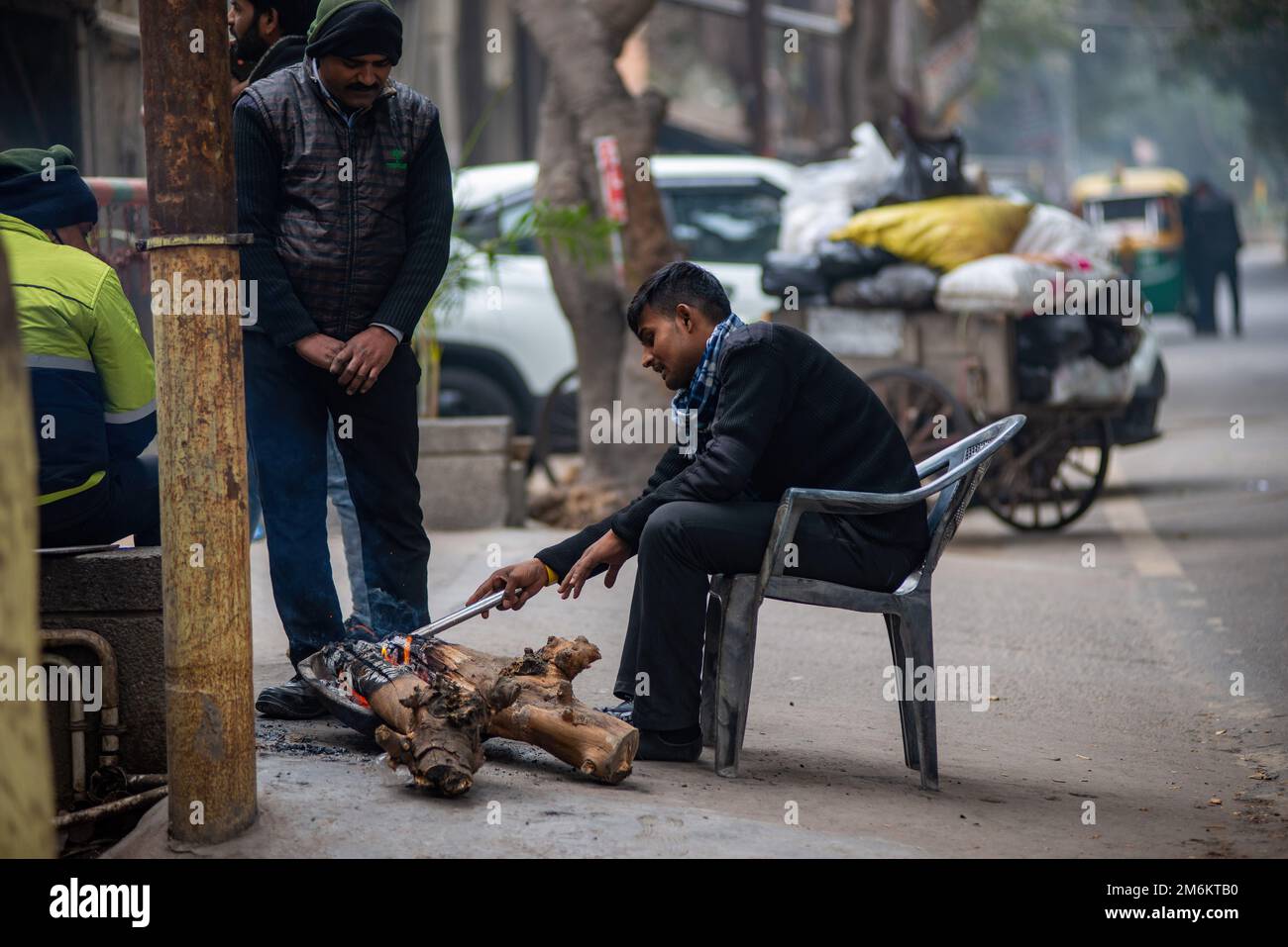Private security guards sit around a bonfire to warm themselves during ...