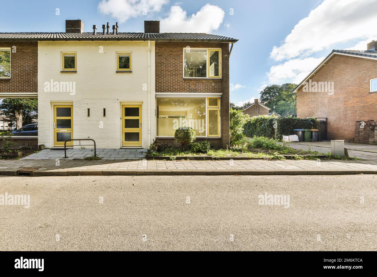 a two story house in the middle of an urban neighborhood, with no cars ...