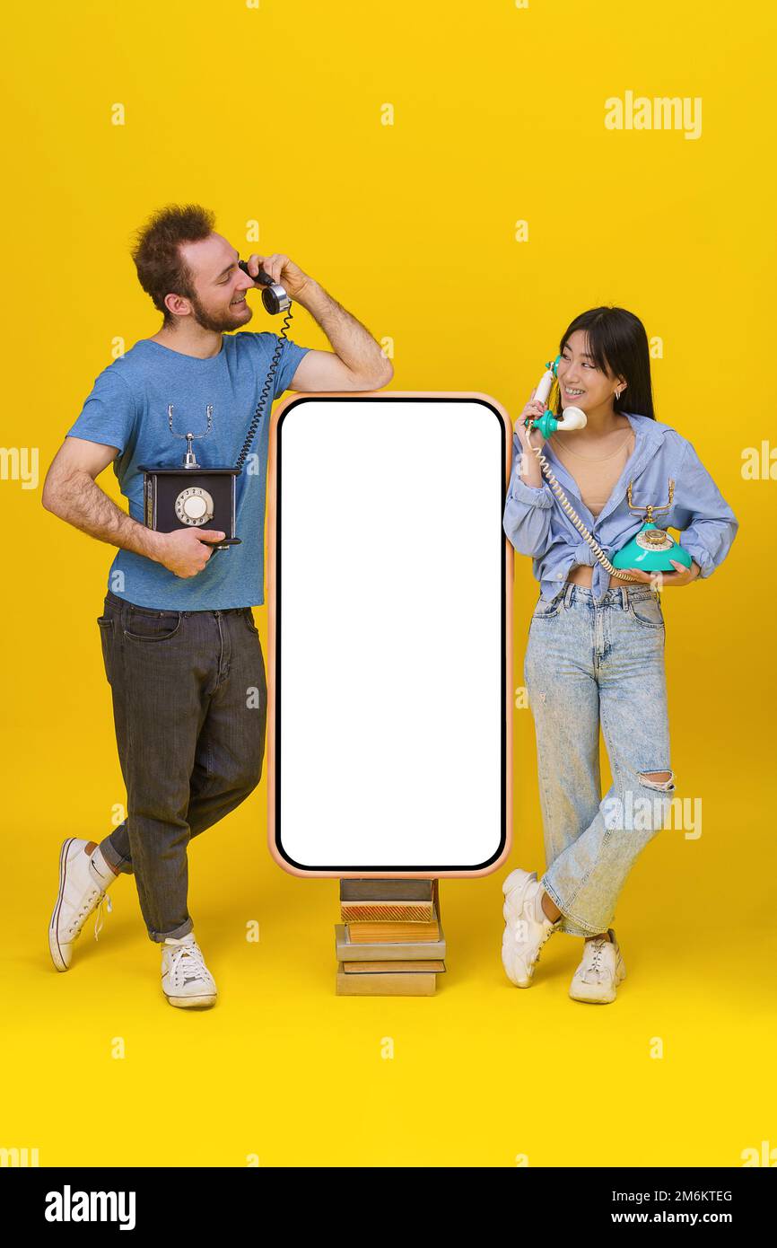 Love talks, handsome guy and asian girl using vintage phones leaned on ...