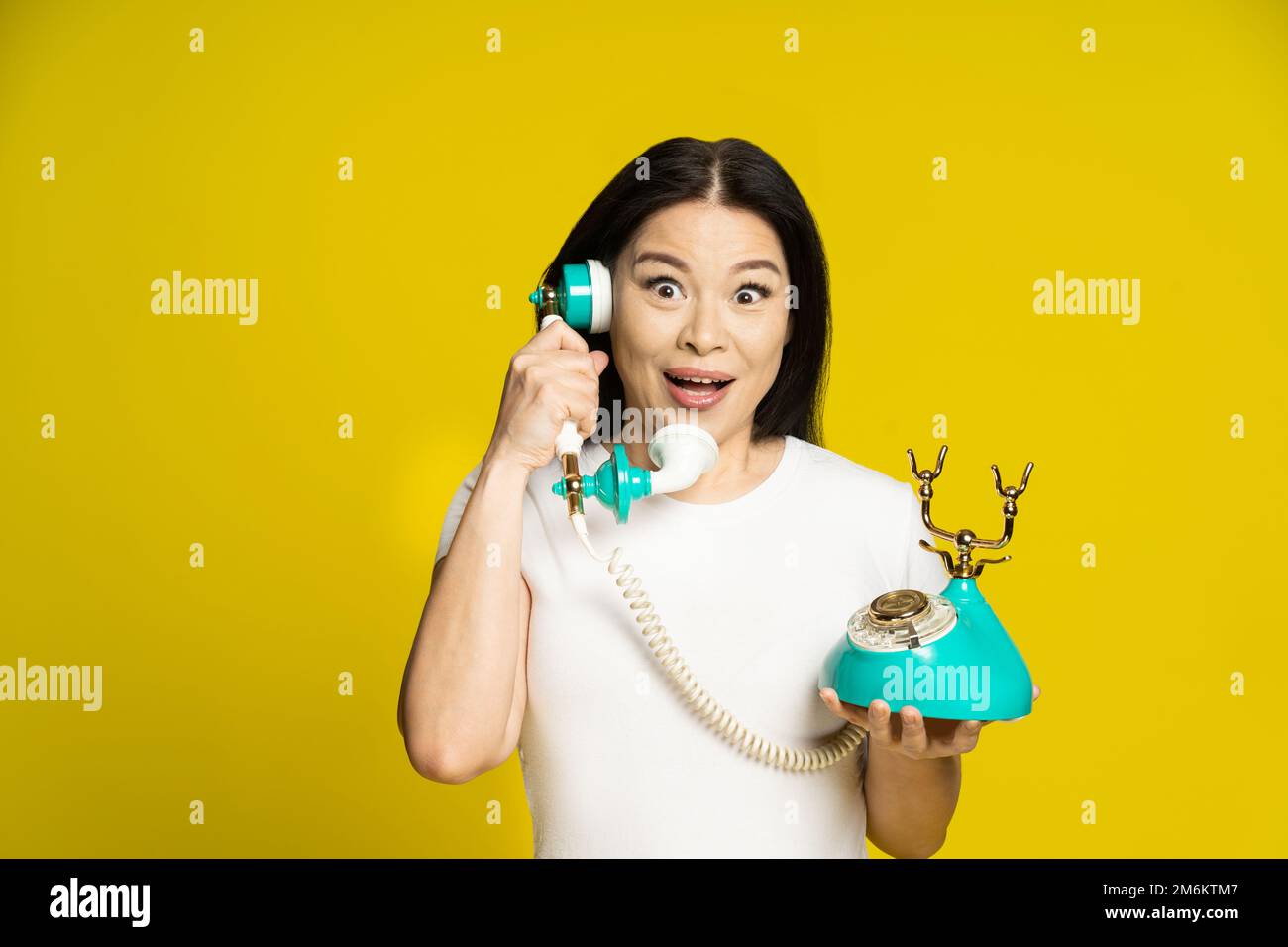 Funny face expression asian woman using vintage, retro telephone in ...