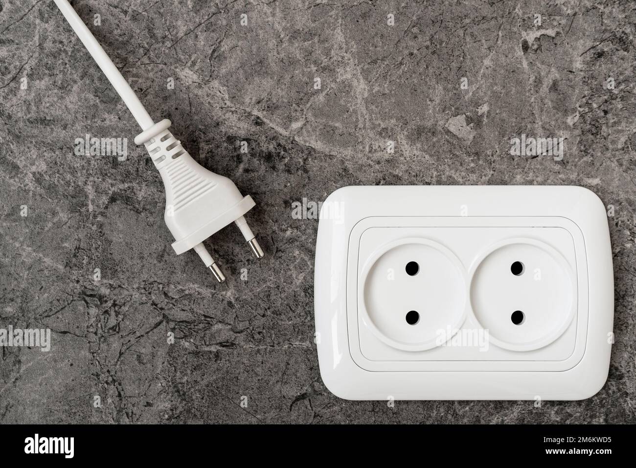 White power plug and electric socket on stone wall Stock Photo - Alamy