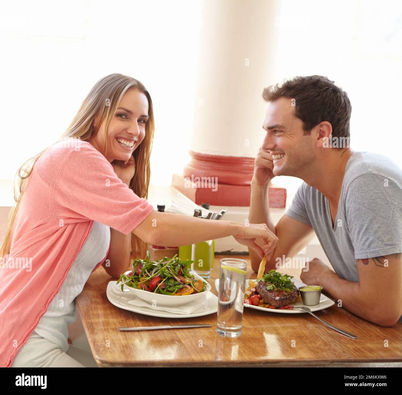 Just a taste...A happy young couple having a healthy lunch together at ...