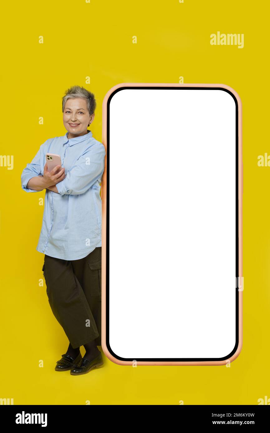 Leaned her back on huge, giant smartphone with white screen grey hair ...