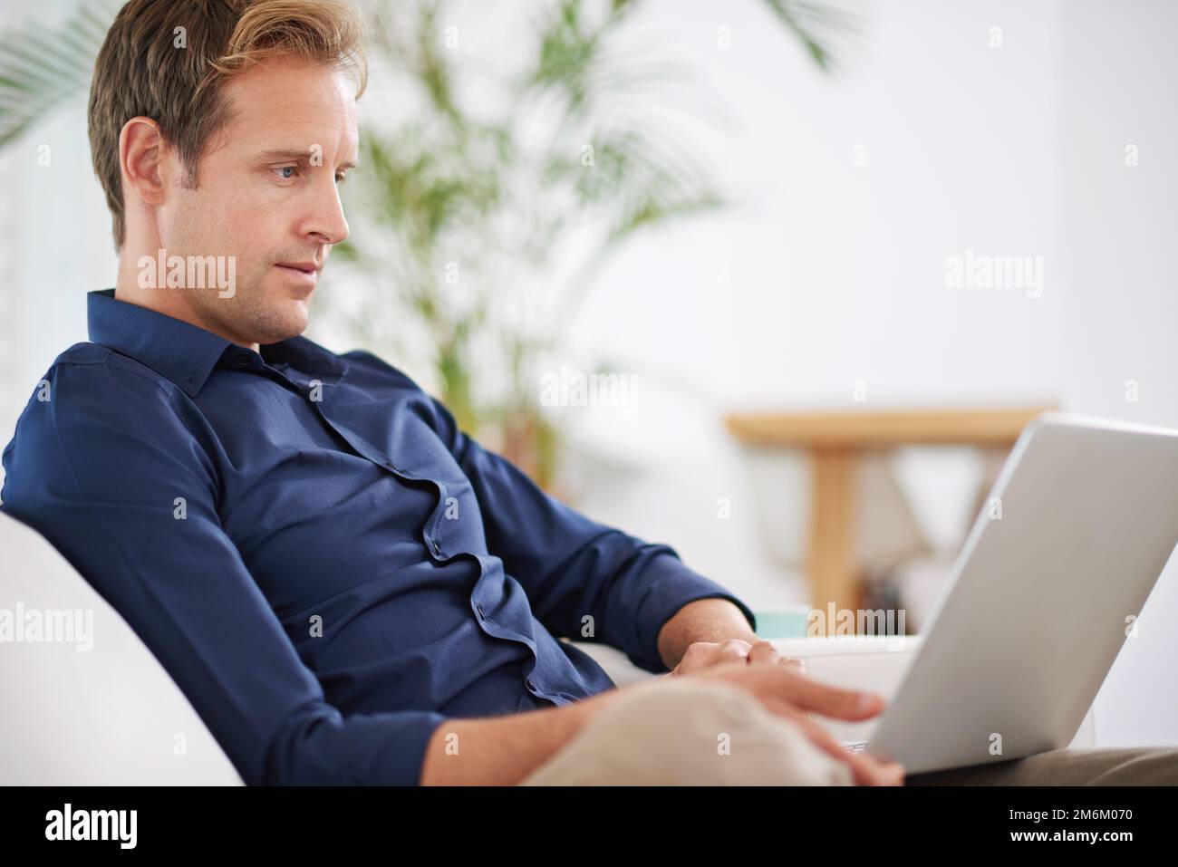 Taking a break from work. a handsome man relaxing at home with his ...