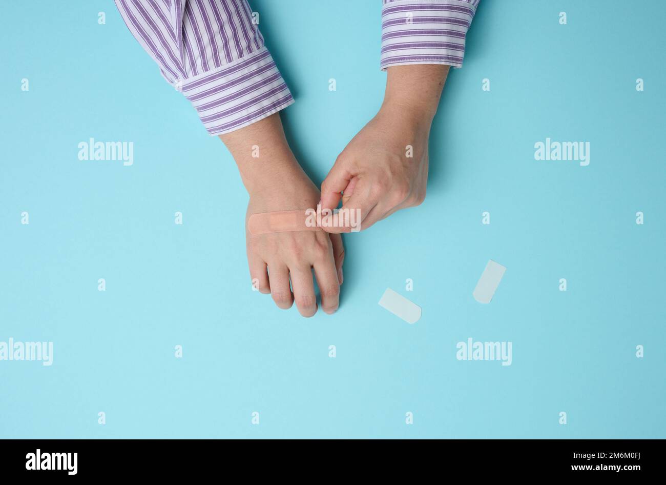 Female hand and brown medical adhesive plaster for the treatment of ...