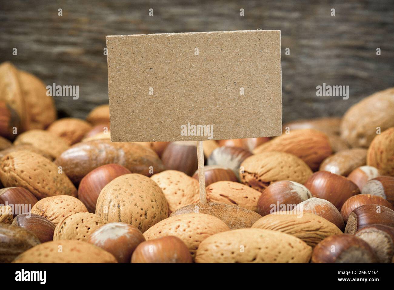 Blank mini paper pointer in a pile of assorted nuts Stock Photo - Alamy