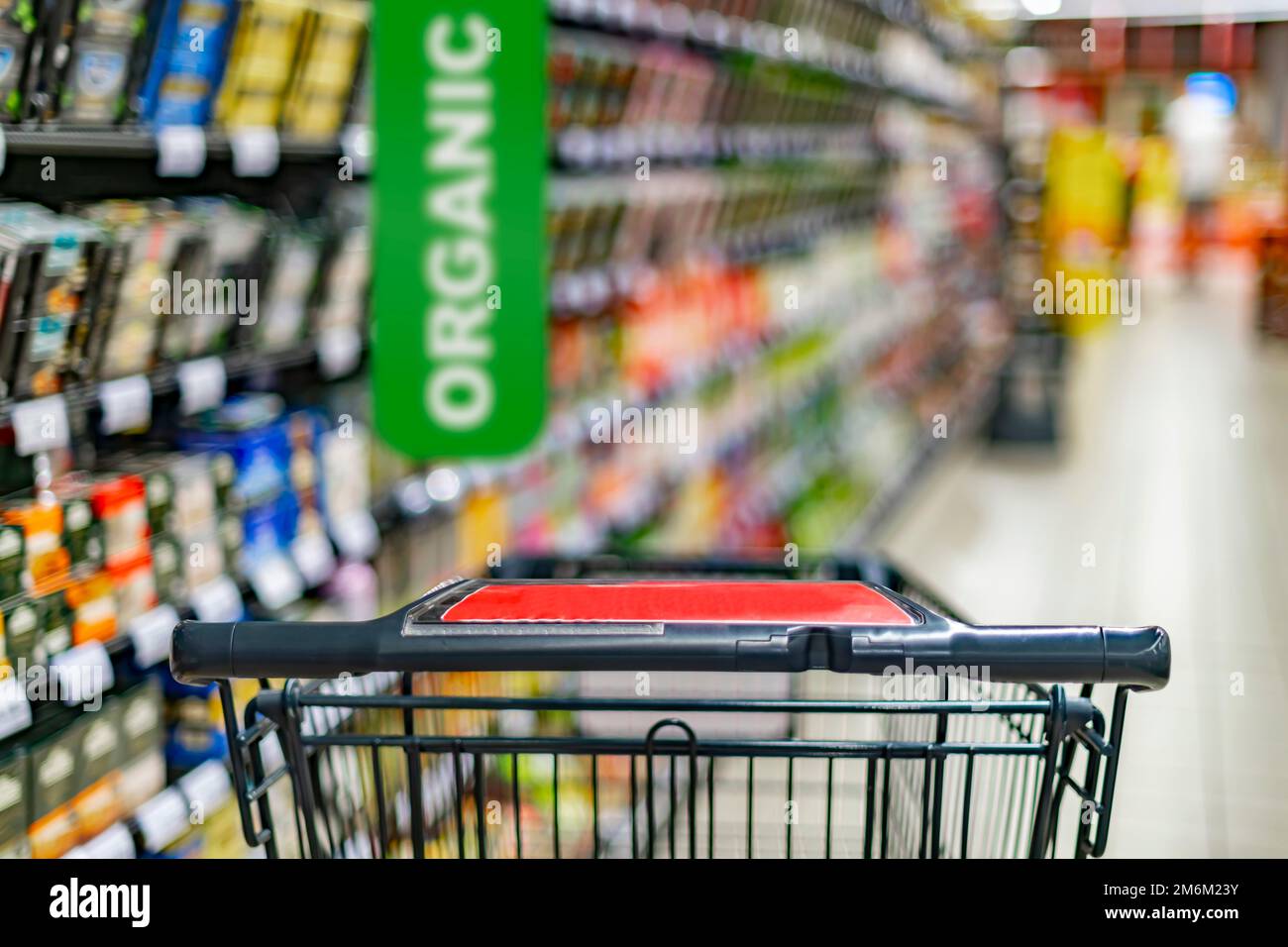 A shopping cart by a store shelf in a supermarket Stock Photo - Alamy