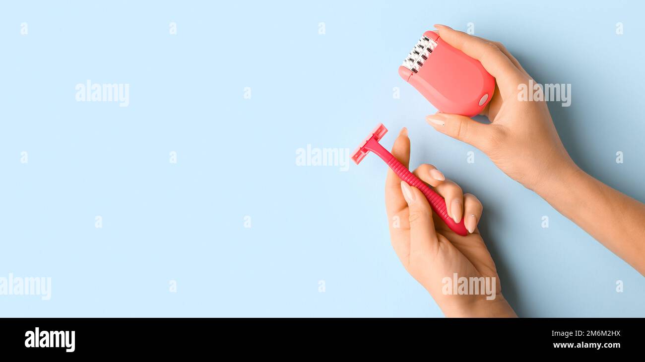 Female hands with epilator and shaving razor on blue background with ...