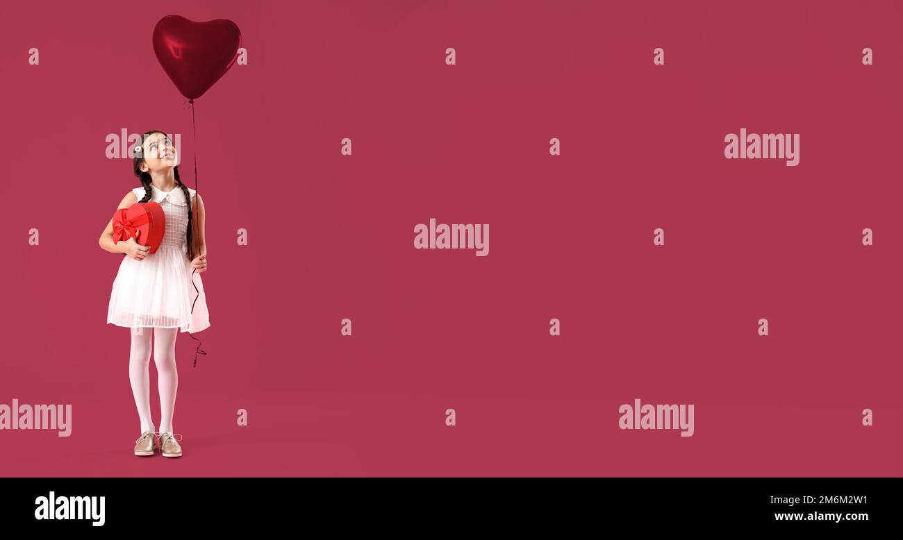 Funny little girl with gift and balloon on color background with space ...