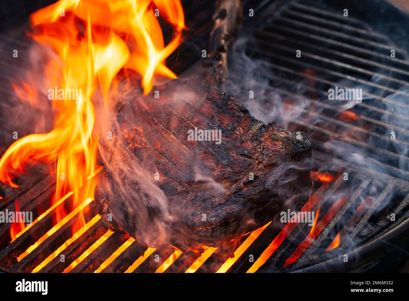 Barbecue Dry Aged Wagyu Tomahawk Steak Offered As Close Up On A Charcoal Grill With Fire And