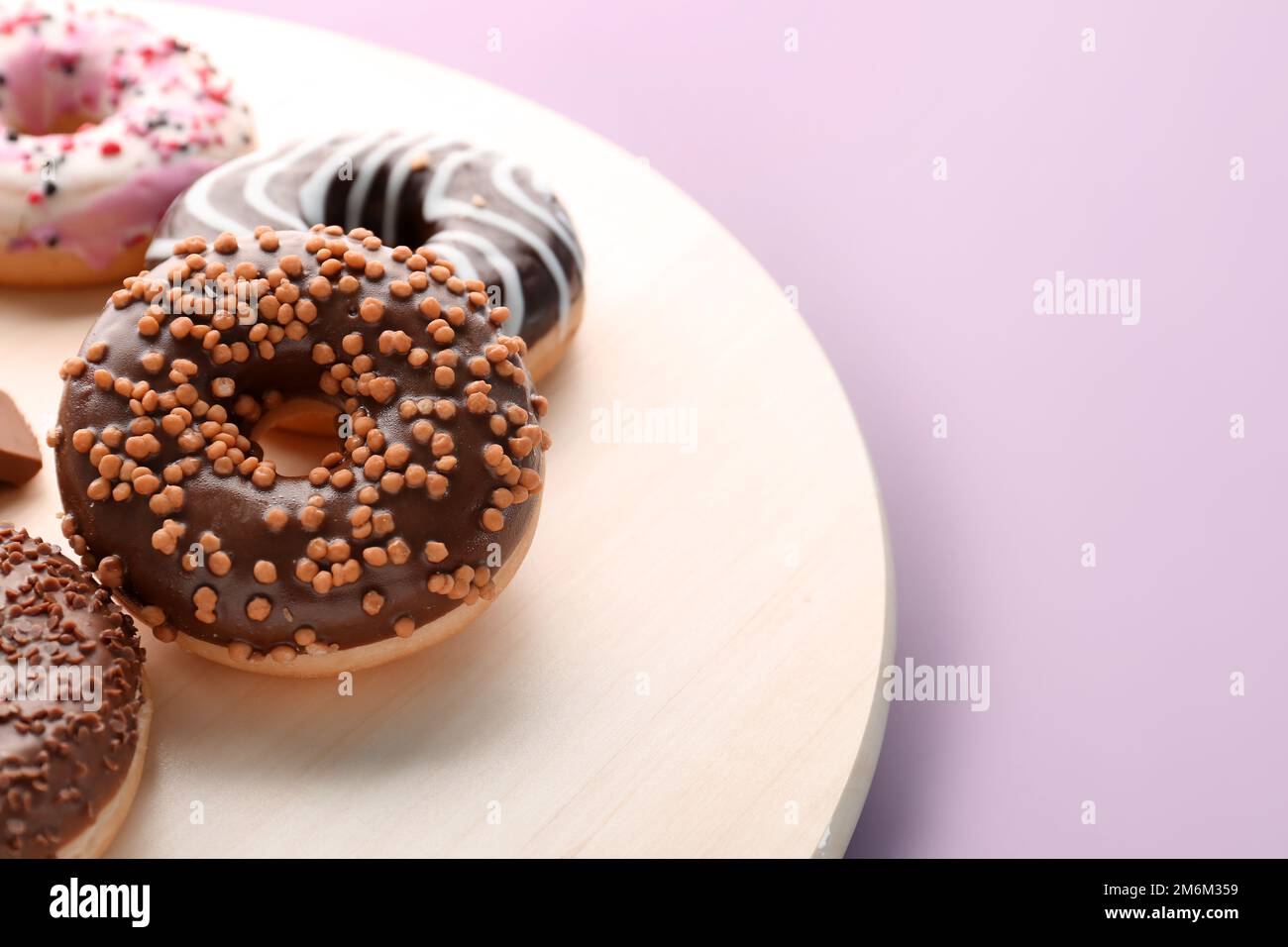 Wooden board with delicious donuts on color background, closeup Stock ...