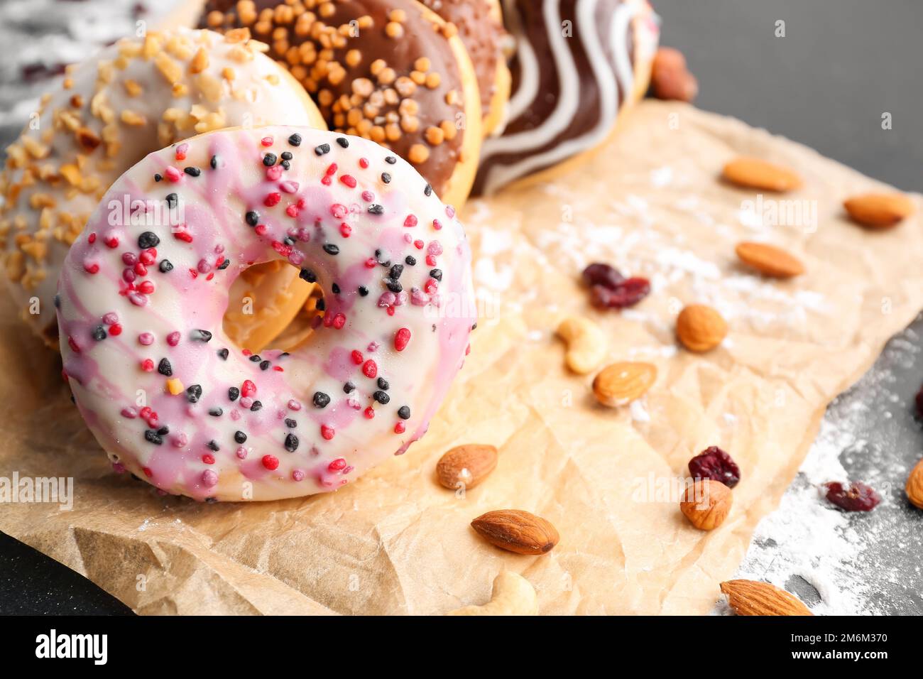 Sheet of baking paper with tasty donuts and nuts, closeup Stock Photo ...