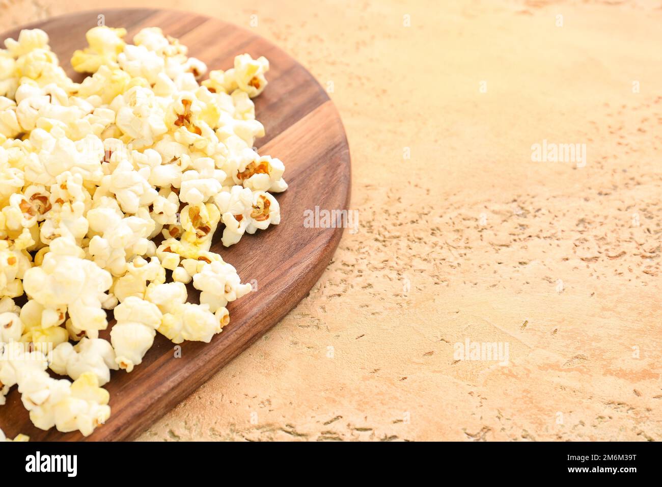Wooden board with tasty popcorn on color background Stock Photo - Alamy