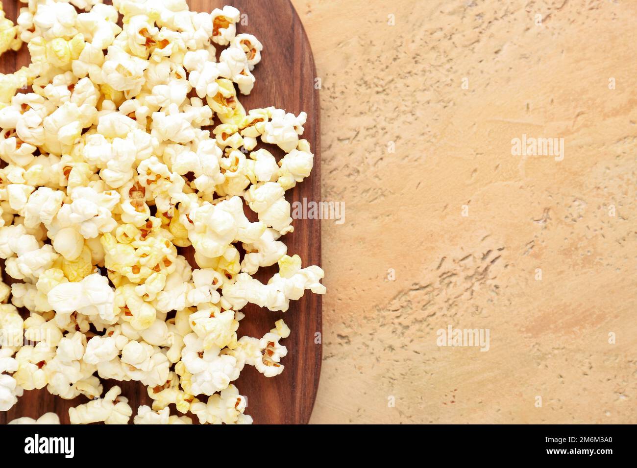 Wooden board with tasty popcorn on color background, closeup Stock ...