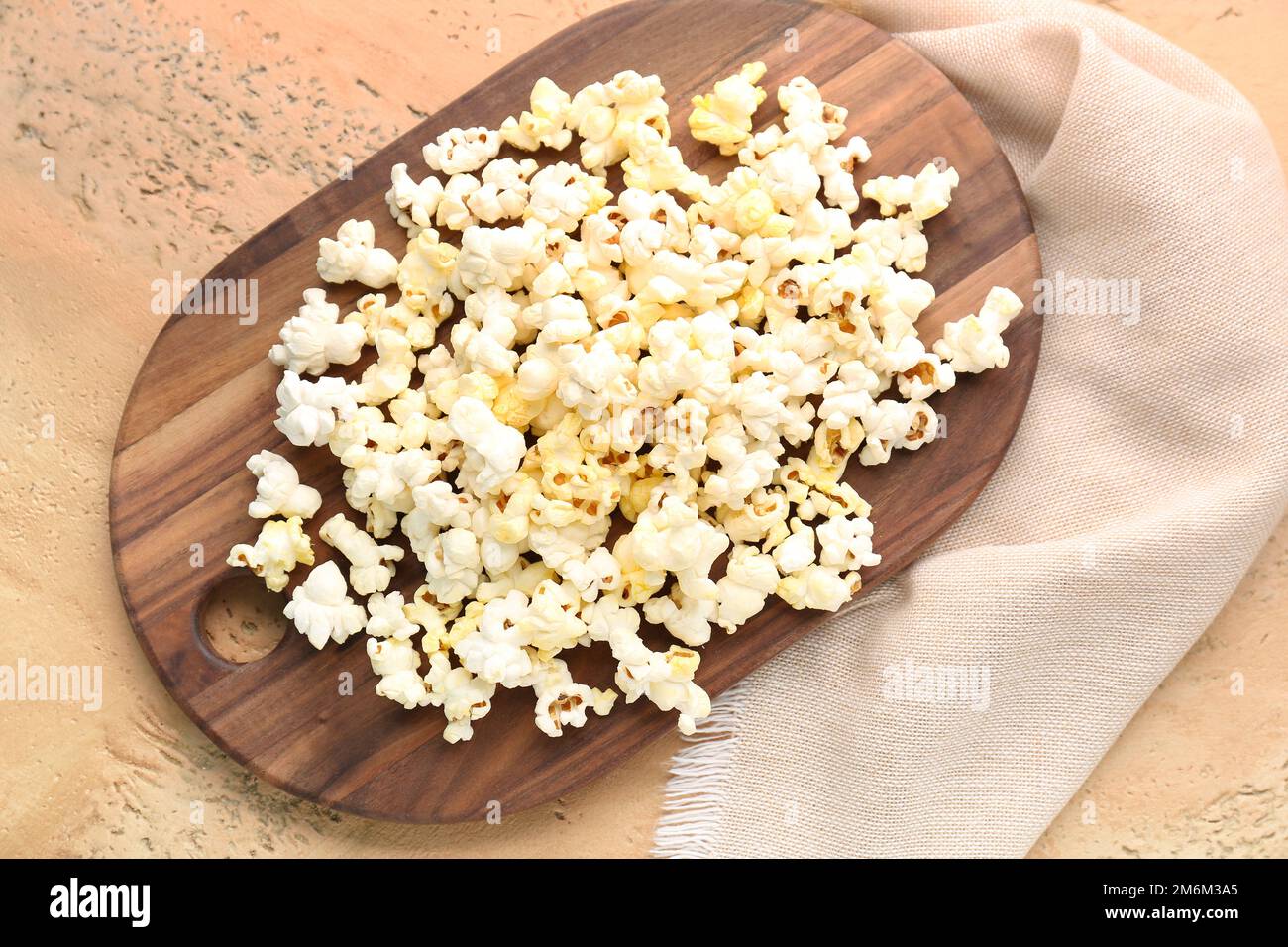 Wooden board with tasty popcorn on color background Stock Photo - Alamy
