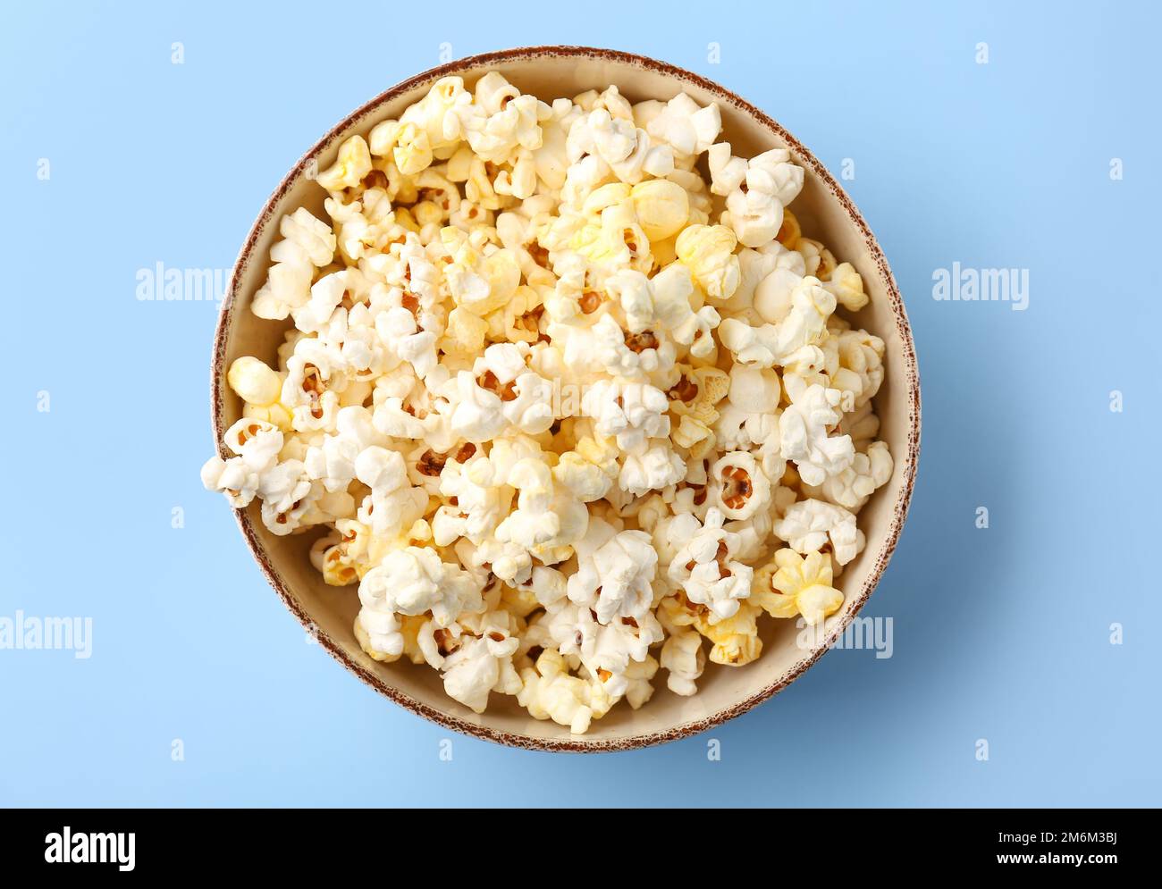 Bowl full of tasty popcorn on color background Stock Photo - Alamy