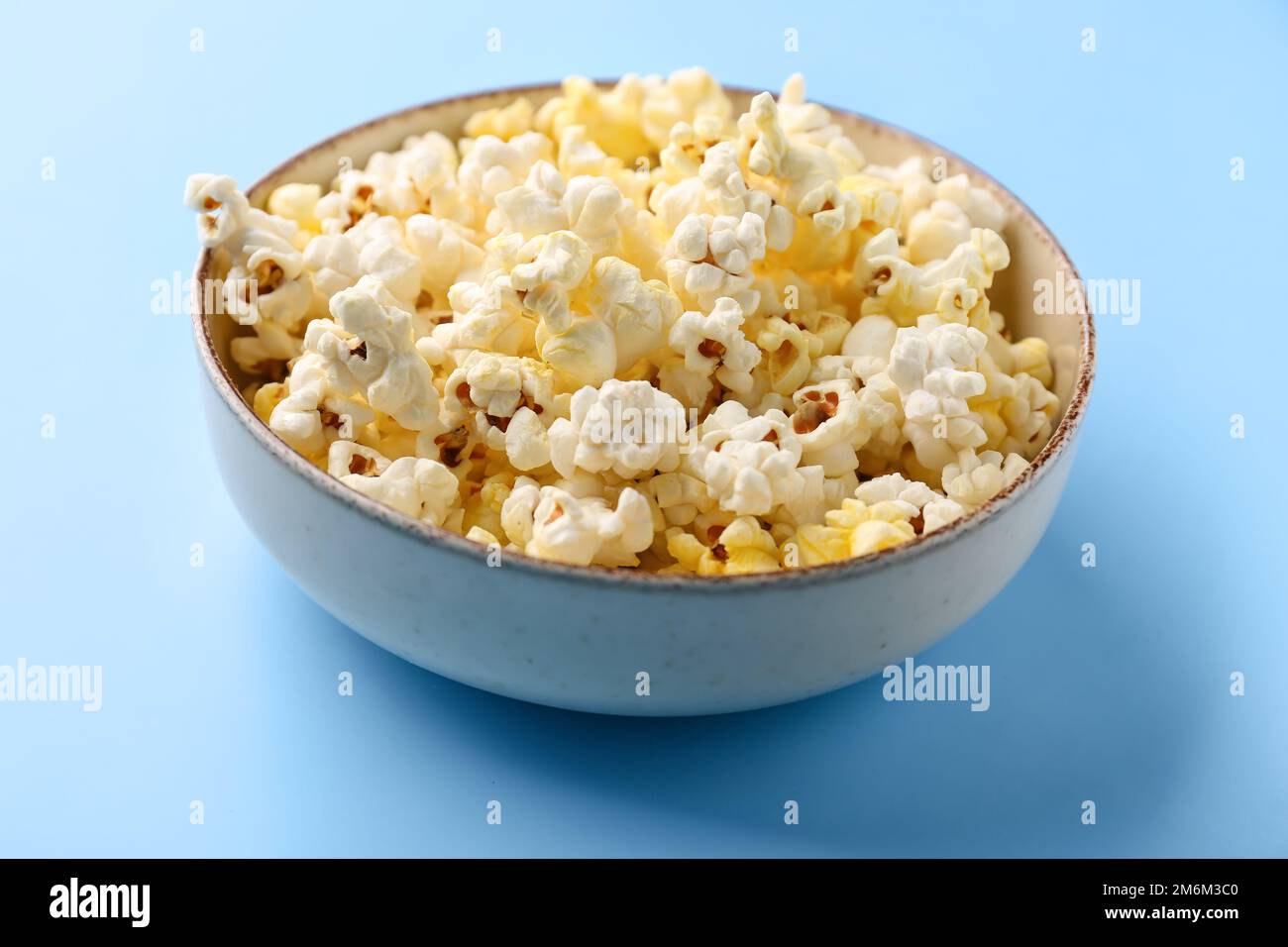 Bowl full of tasty popcorn on color background Stock Photo - Alamy