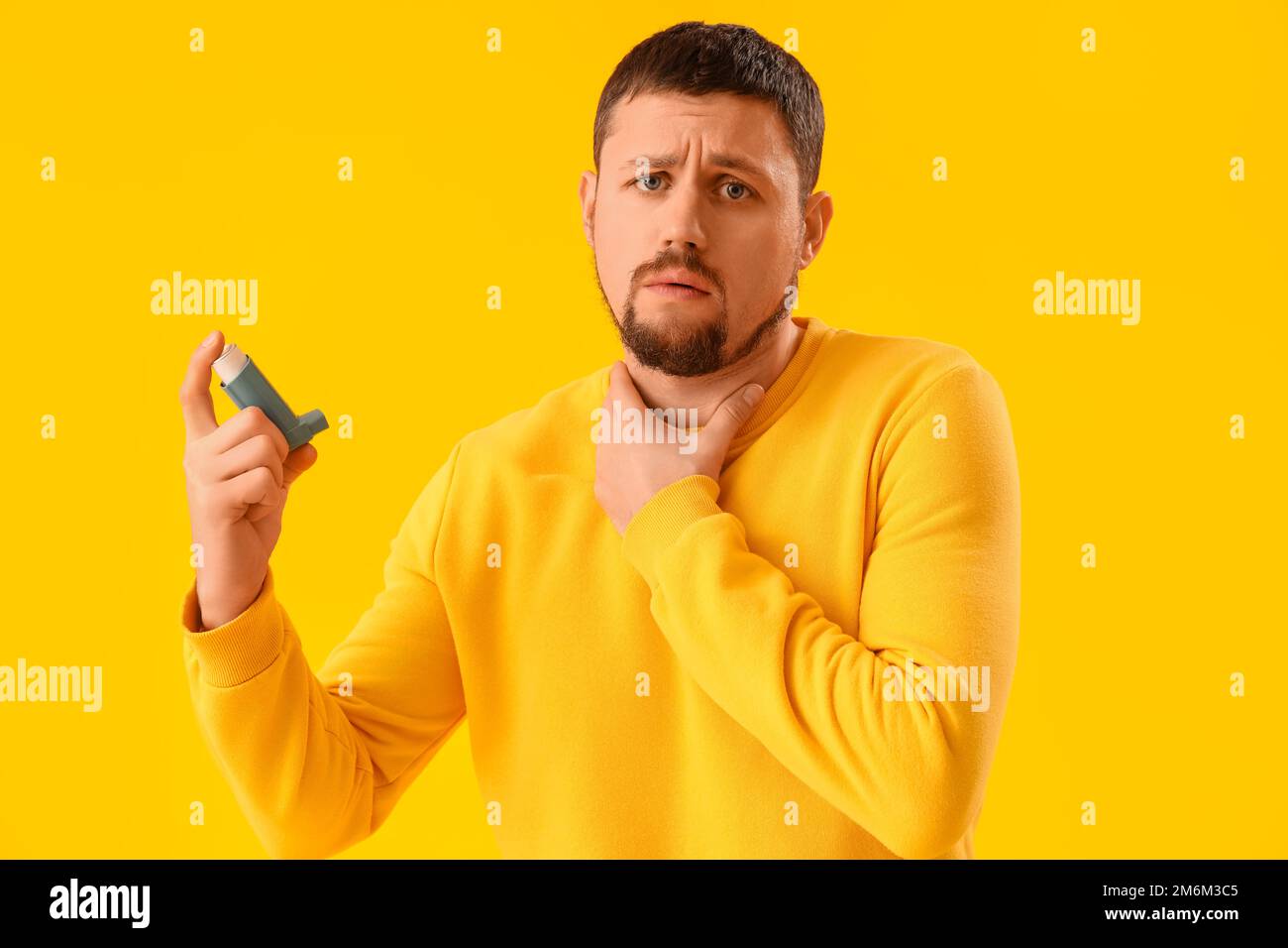 Sick man with inhaler on yellow background Stock Photo - Alamy