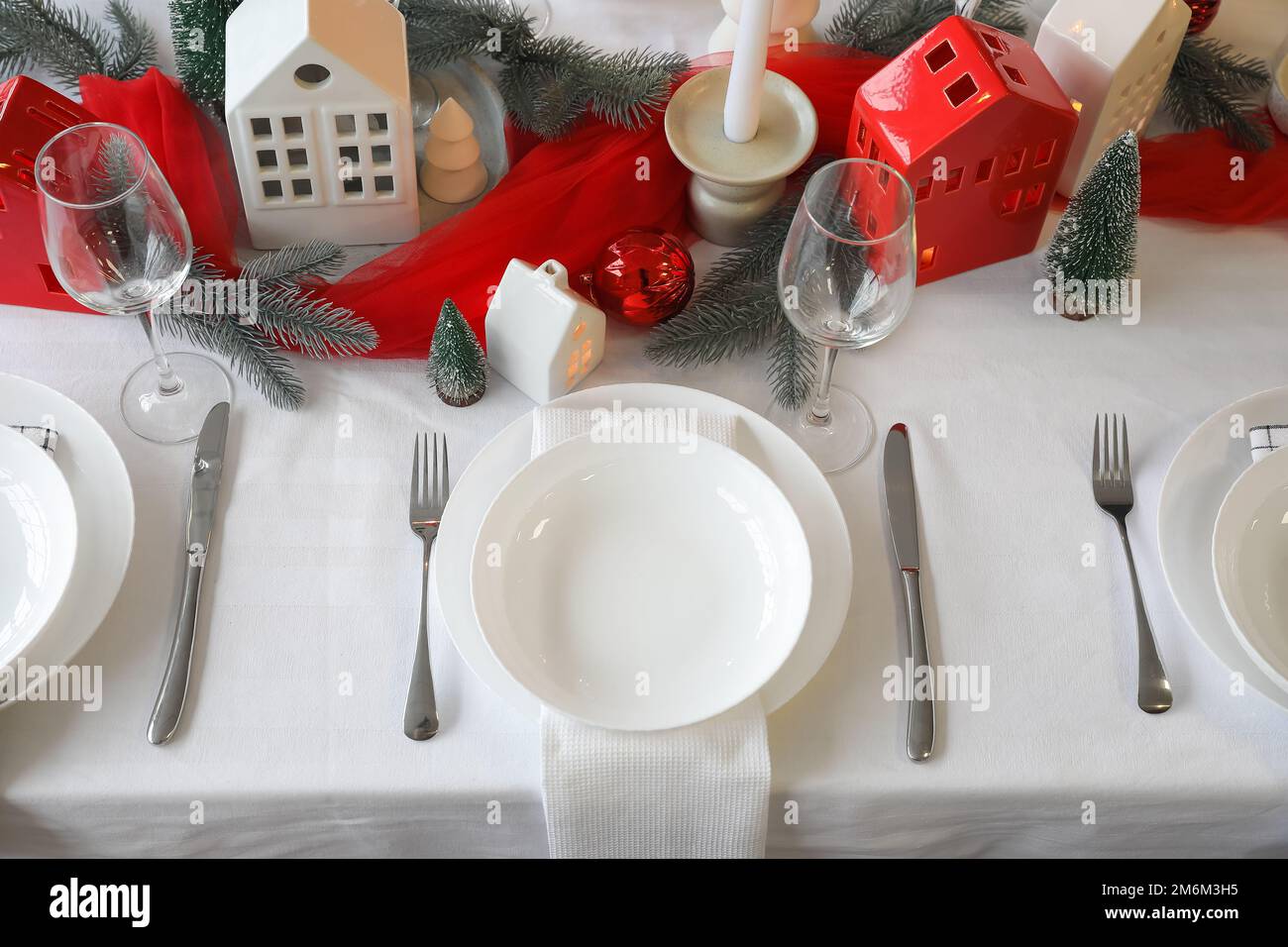 Christmas table setting with candle holders and fir branches in dining ...
