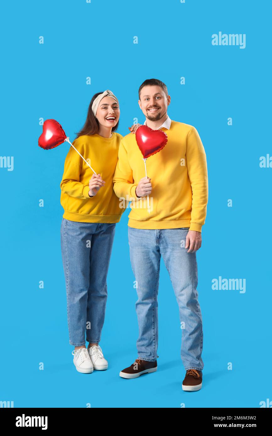 Happy couple in love with balloons on blue background. Valentine's Day ...