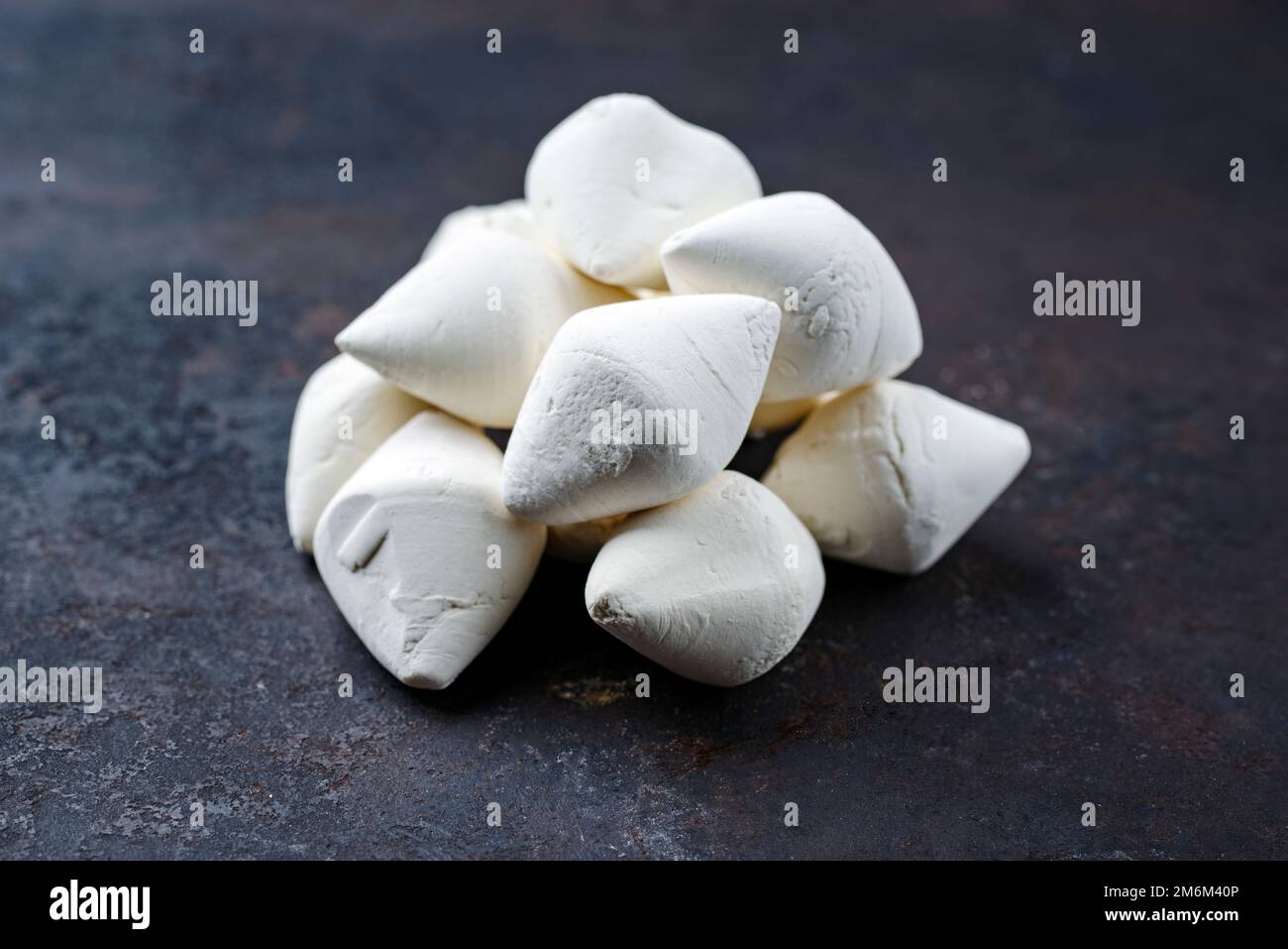 Traditional Afghan dried curd kashk pieces as close-up on black rustic ...