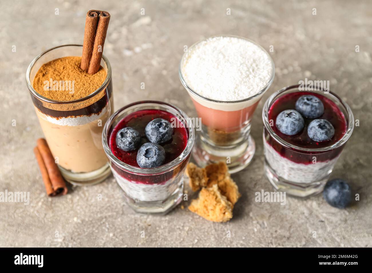 Shots of various pudding with blueberry, cinnamon and cookie pieces on ...