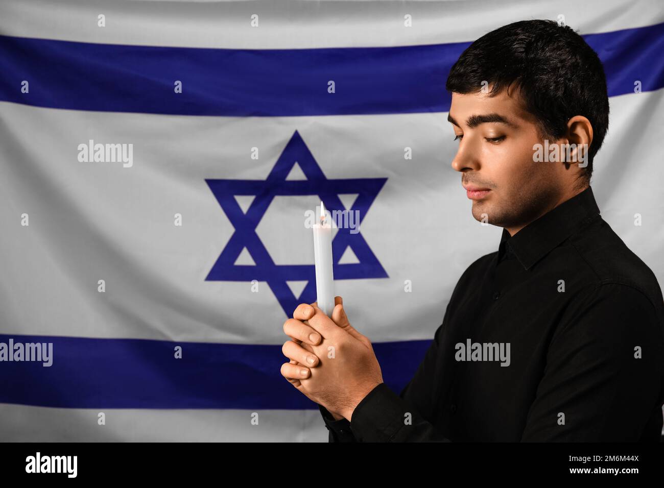 Jewish man with candle against flag of Israel. Honoring victims of ...