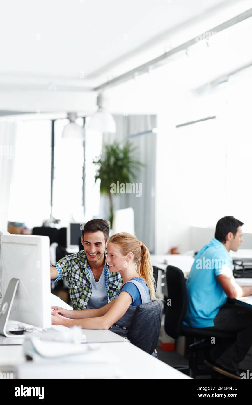 Showing her the ropes. Two colleagues talking while working on the ...