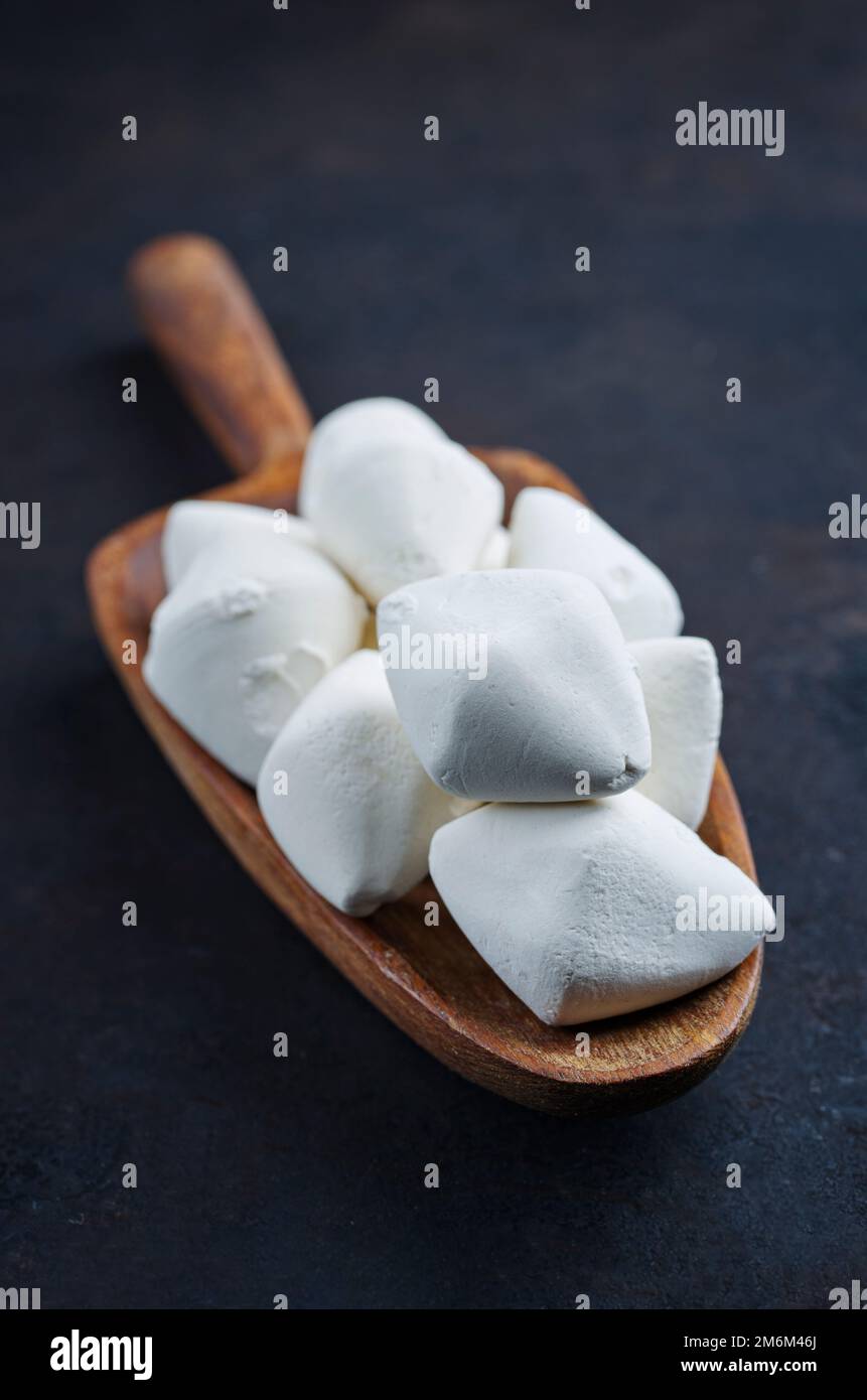 Traditional Afghan dried curd kashk pieces on a small wooden shovel as ...