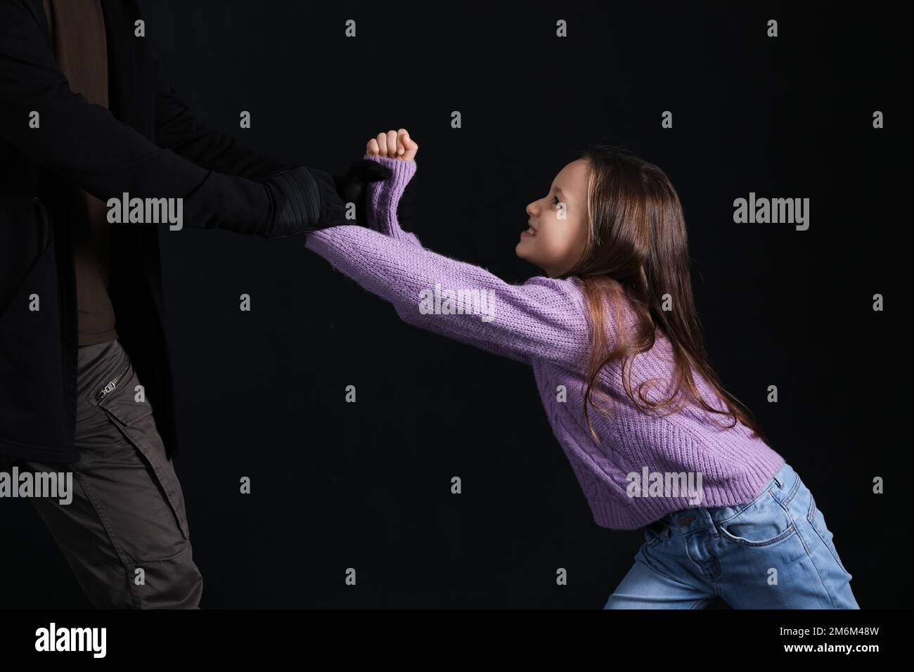 Terrorist and scared little hostage on dark background Stock Photo - Alamy