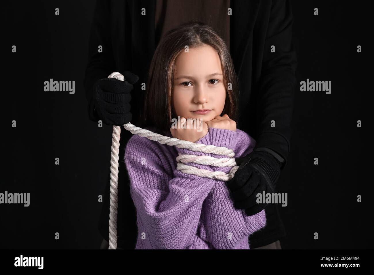 Terrorist and scared little hostage on dark background Stock Photo - Alamy