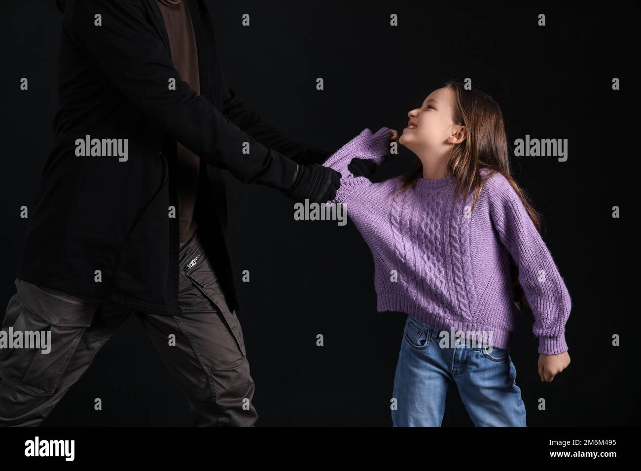 Terrorist and scared little hostage on dark background Stock Photo - Alamy