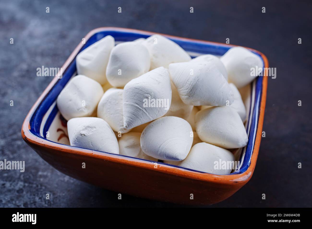 Traditional Afghan dried curd kashk pieces ceramic bowl as close-up on ...