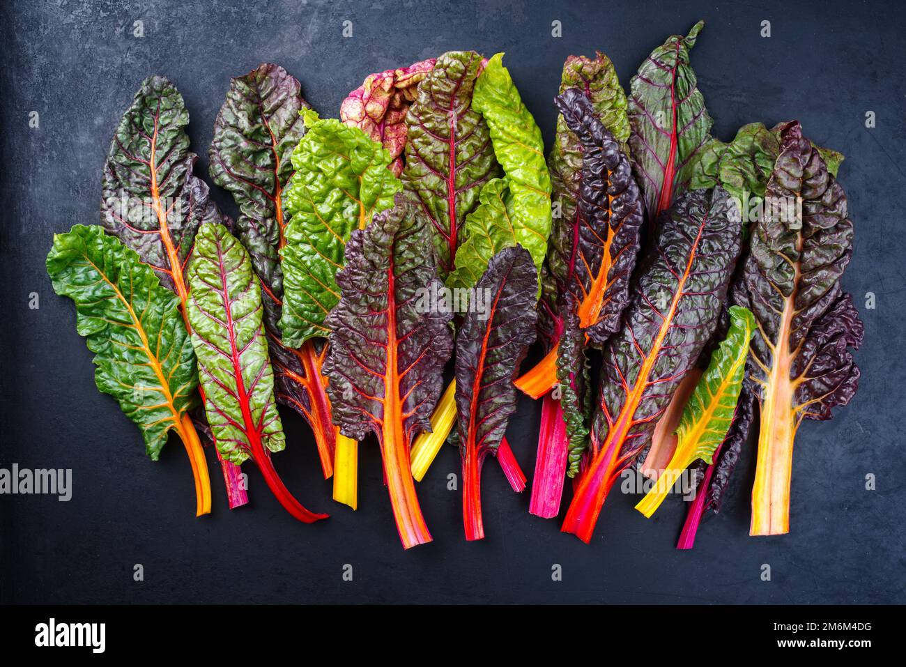 Raw colourful chard offered as a close-up on a rustic black board Stock ...