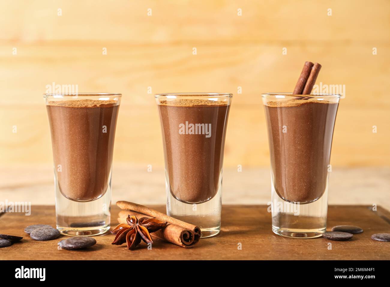 Board with shots of chocolate pudding, cinnamon and anise on wooden ...