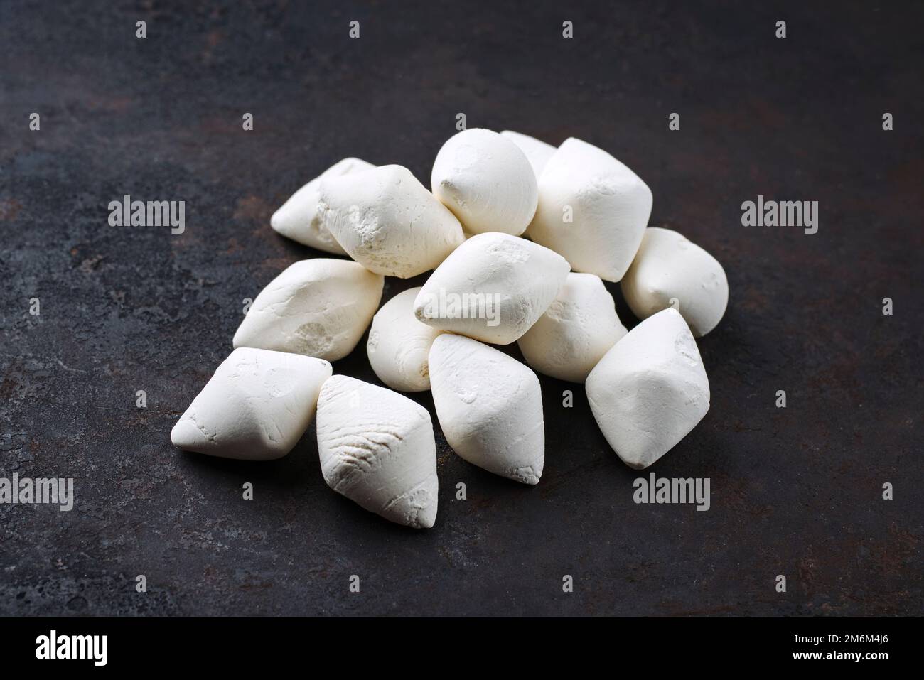 Traditional Afghan dried curd kashk pieces as close-up on black rustic ...