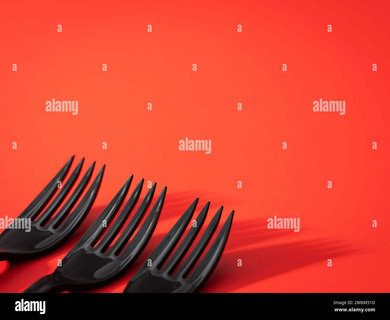 Black fork on a red background Stock Photo - Alamy