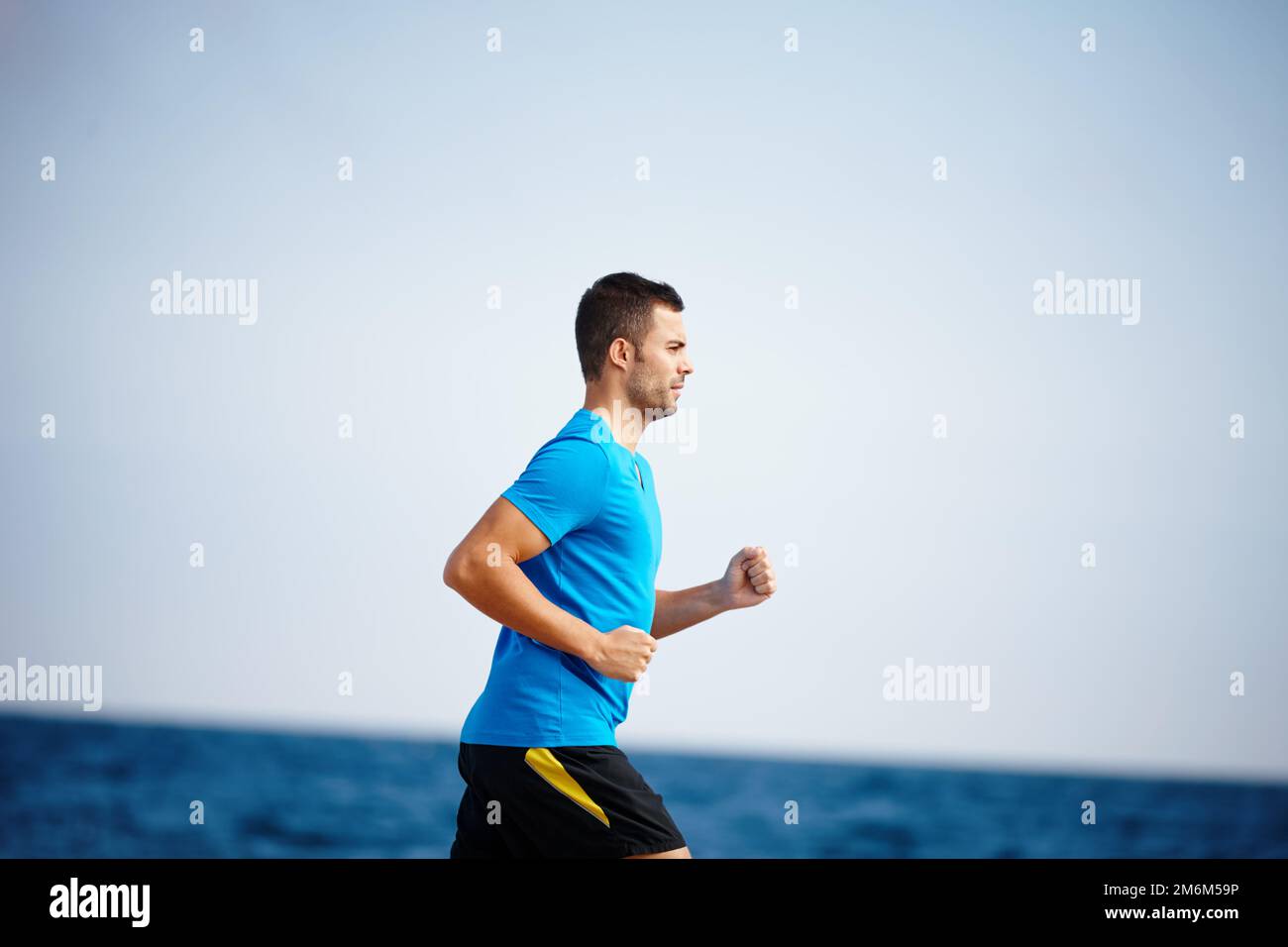 Hes focused on getting fit. a handsome young man running on the beach ...