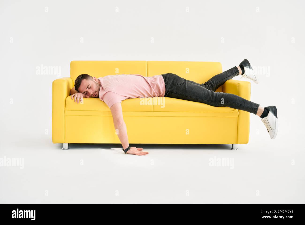 Funny frustrated exhausted man sleeping on sofa over white background ...