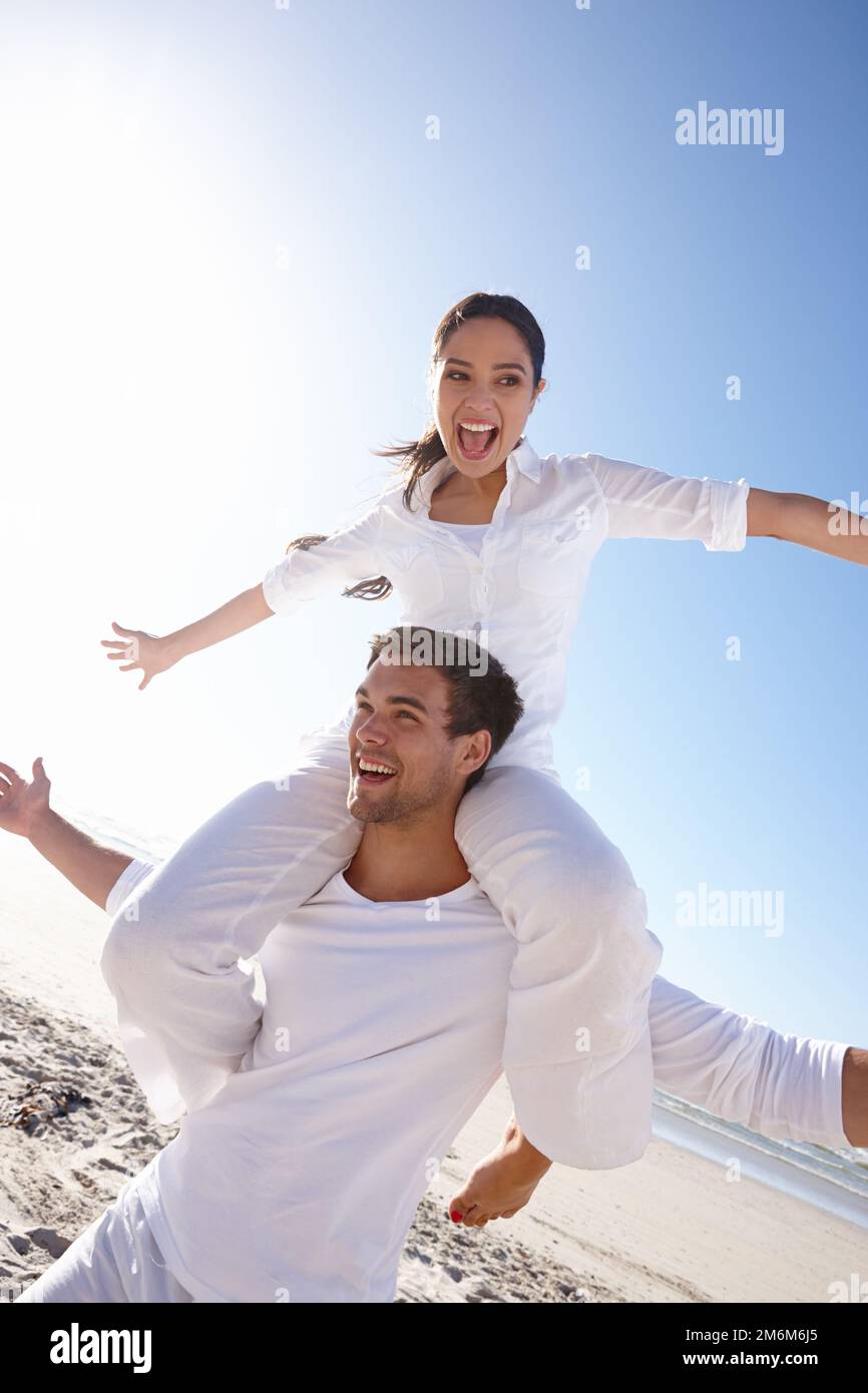 Living life in freedom. a young man carrying his girlfriend on his ...