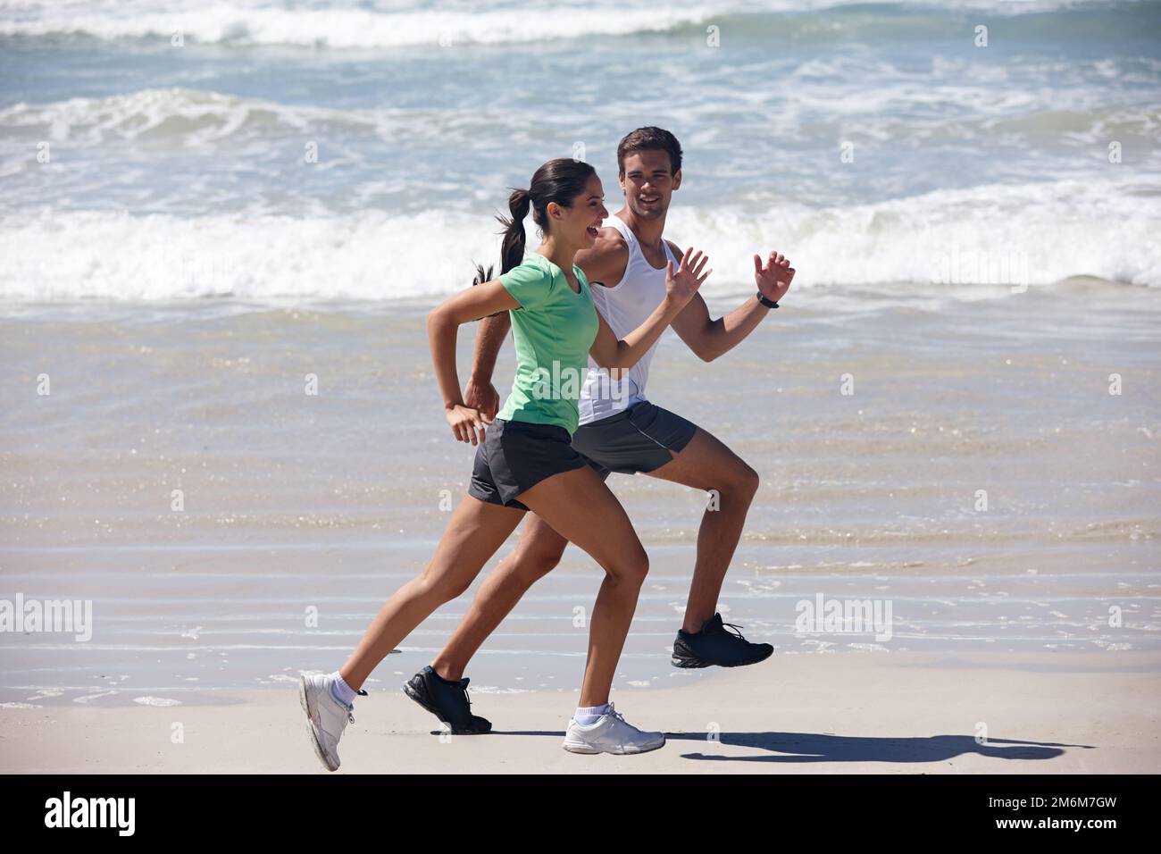Good things come to those who sweat. a young couple jogging together on ...