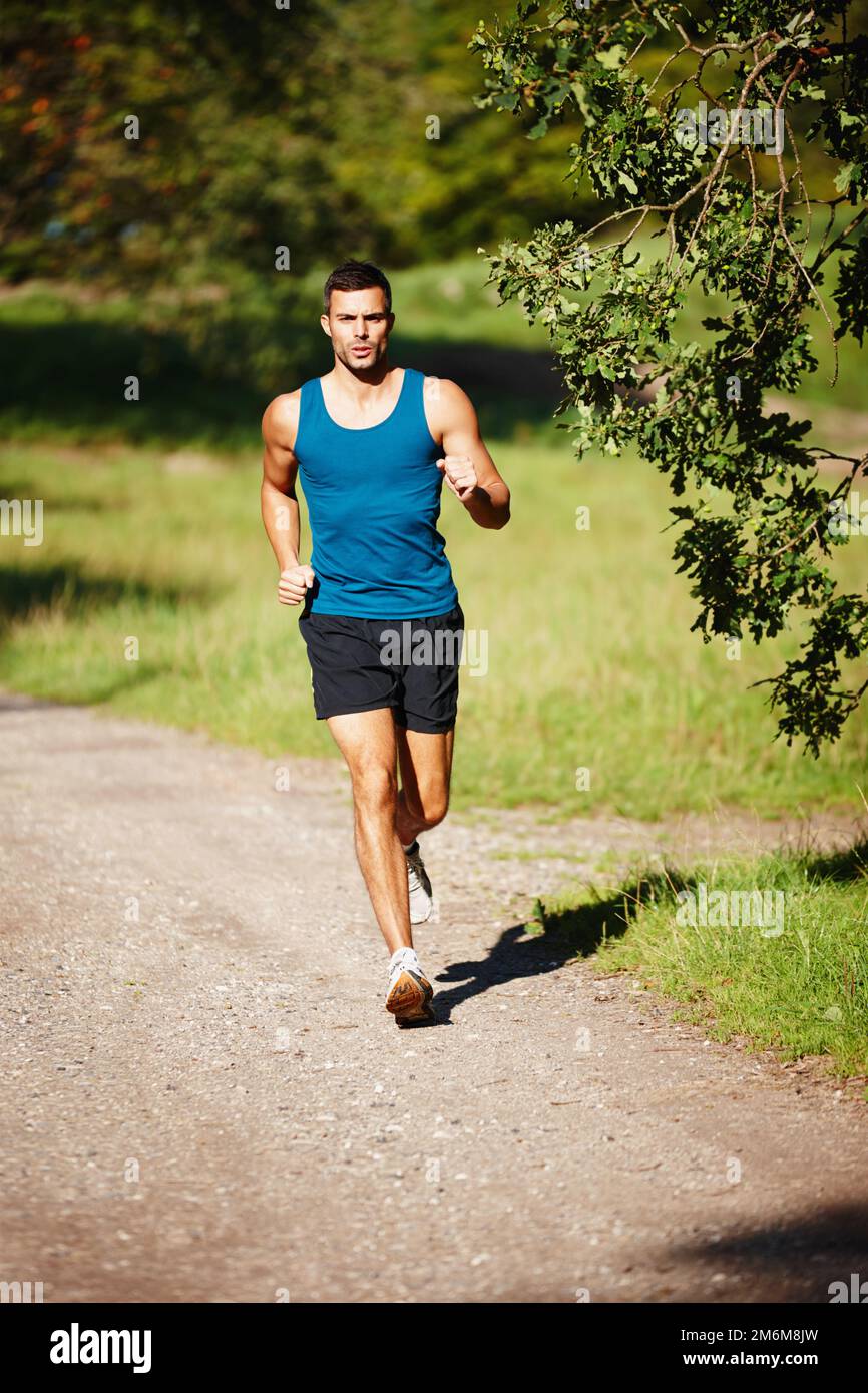 He runs 7-days a week. a handsome young man taking a jog outdoors Stock ...