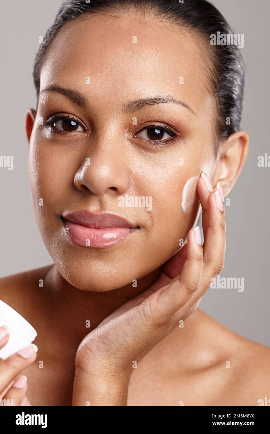 D-I-Y facials. a beautiful young woman applying face cream while ...